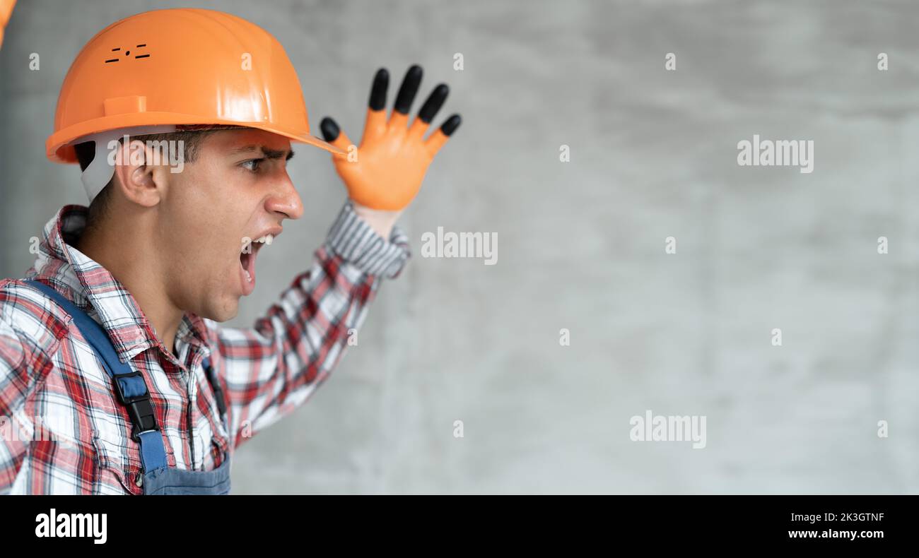 Screaming builder in helmet. Young man construction worker in hard hat ...