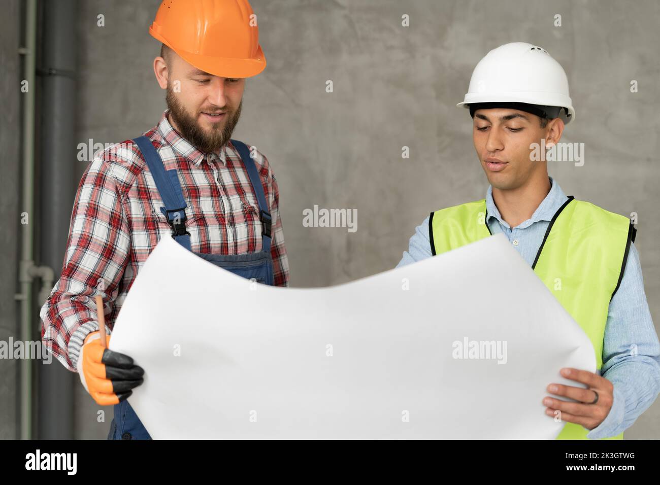 Male architect and builder worker examining blueprint in home ...