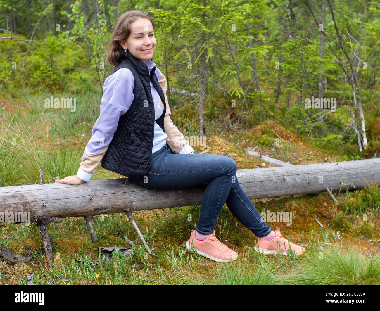 Hiker taking break during woodland walk. Young caucasian woman sitting ...