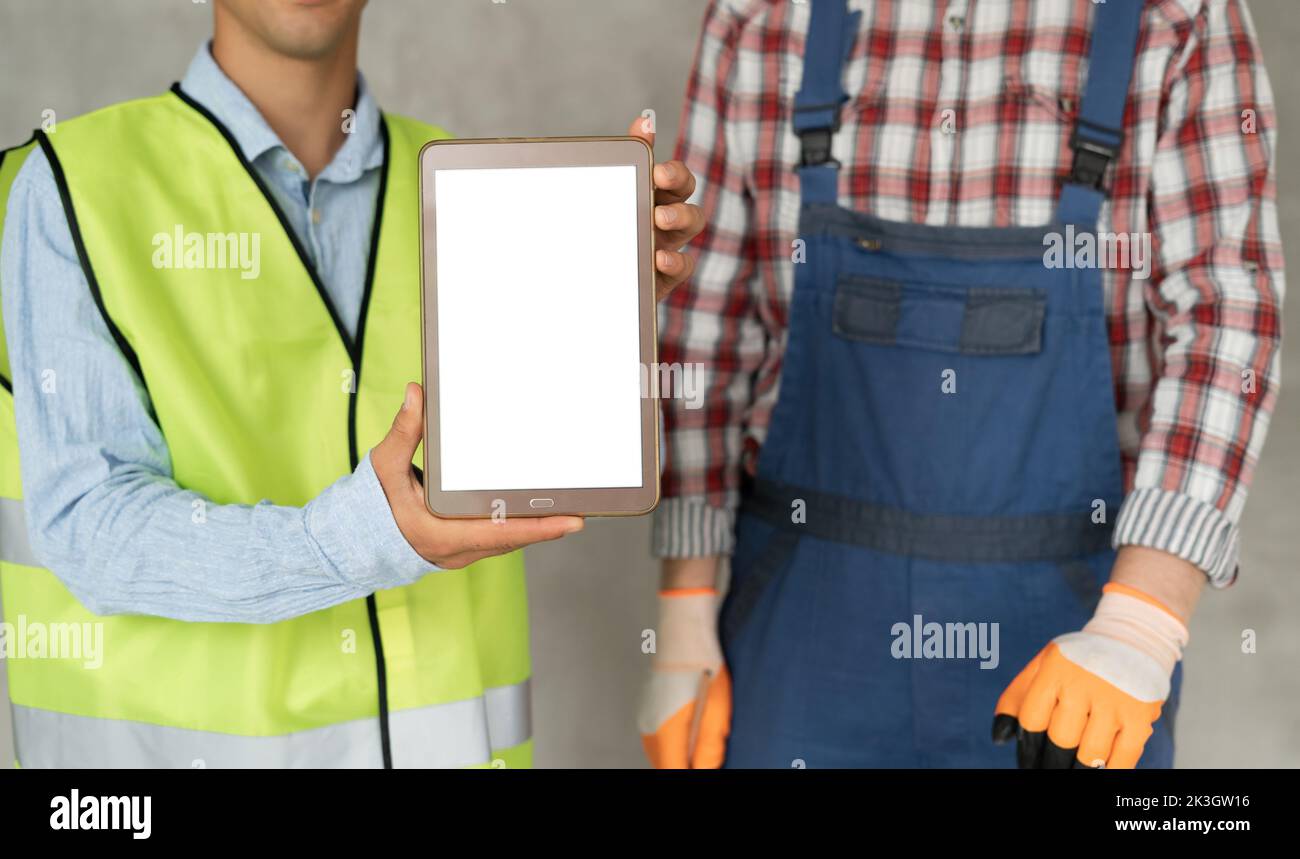 Tablet computer with a blank screen in the hands of an engineer and ...