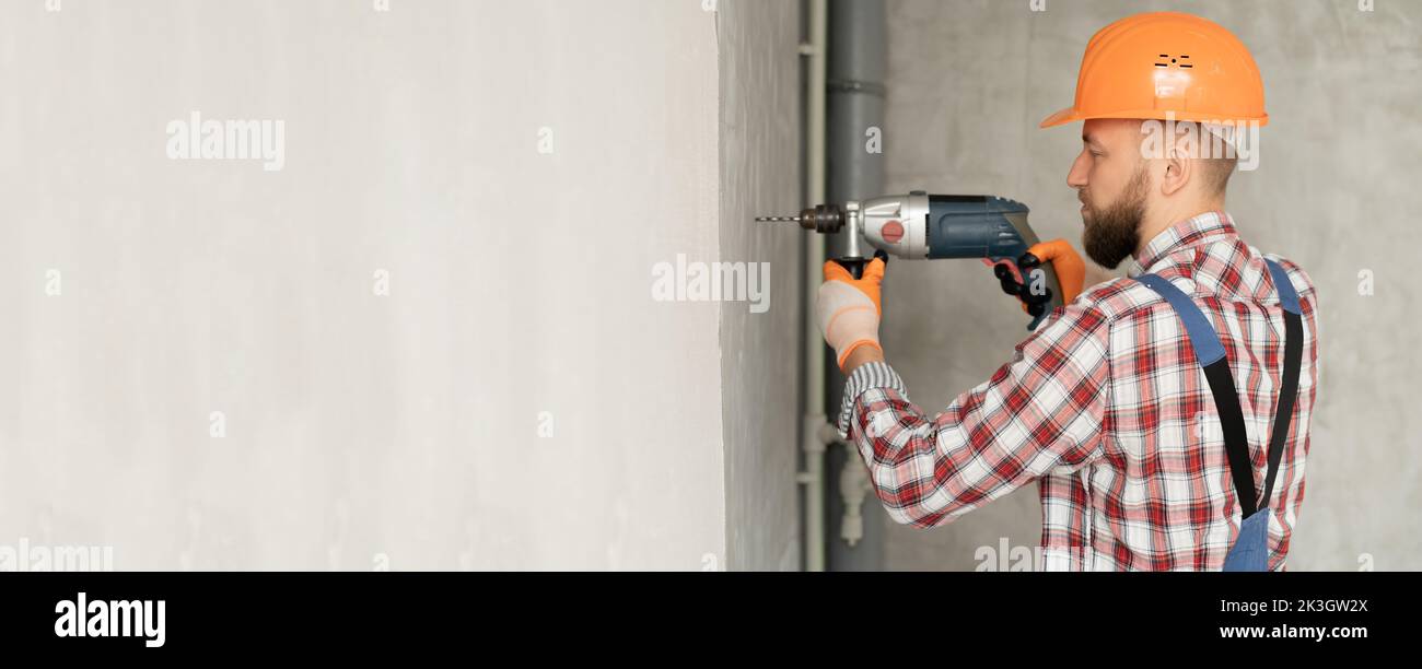 worker builder working perforator with big long drill, drilled concrete ...
