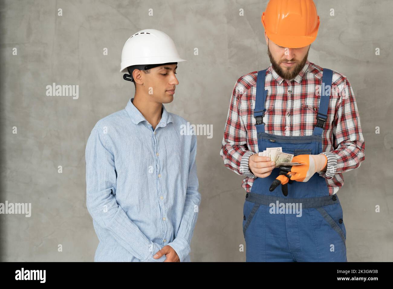 Arabic man pays for the work of foreman builder repairman with dollar ...