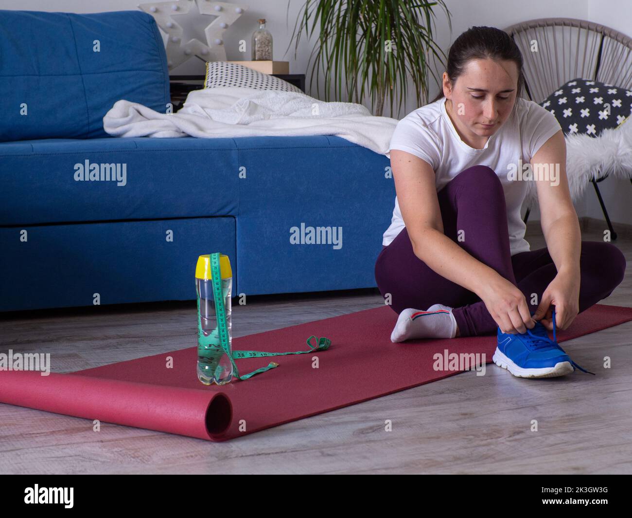 European girl tying sport shoes before training. Concept of fitness ...