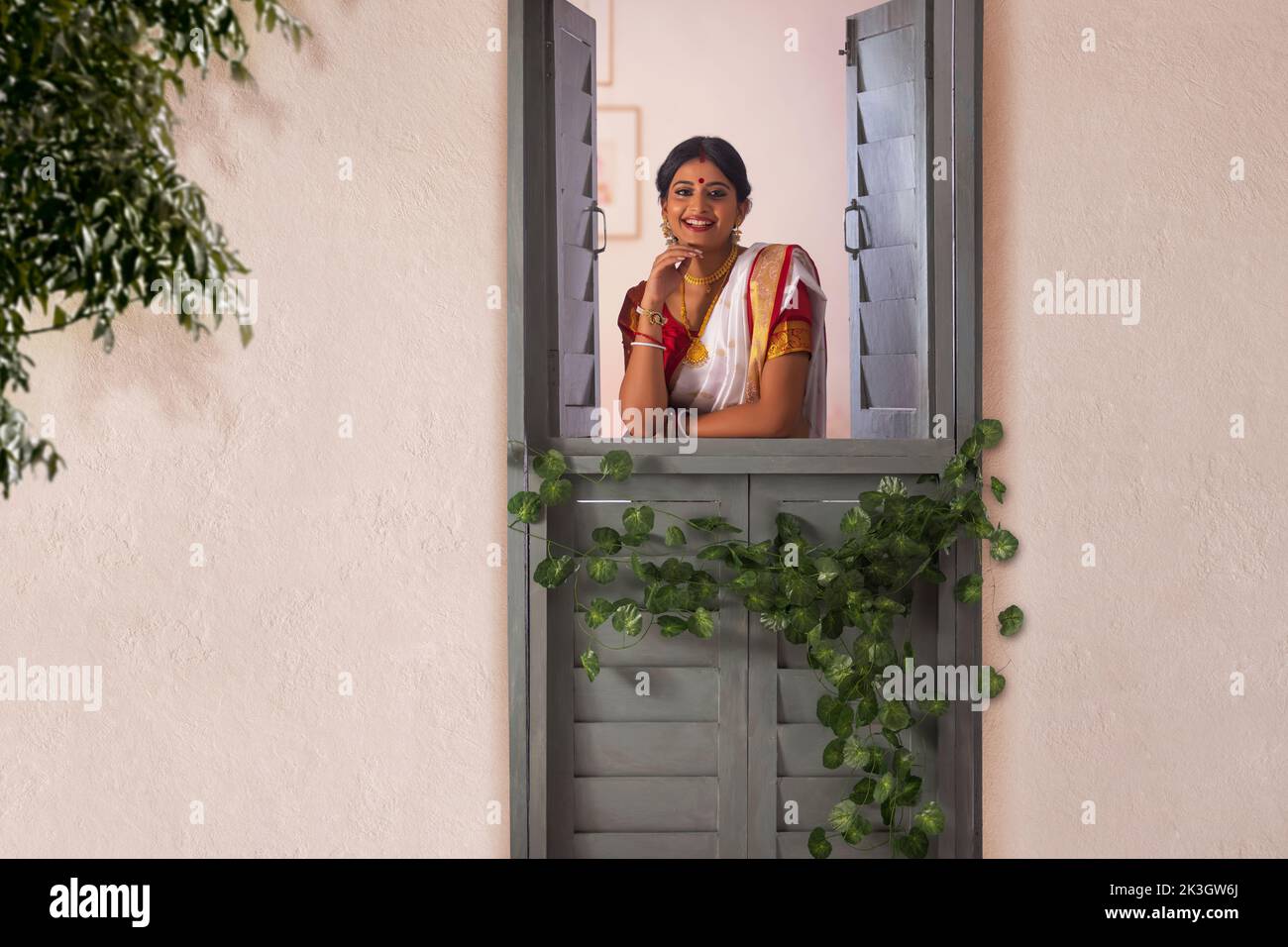 Bengali woman standing by window and looking outside Stock Photo - Alamy