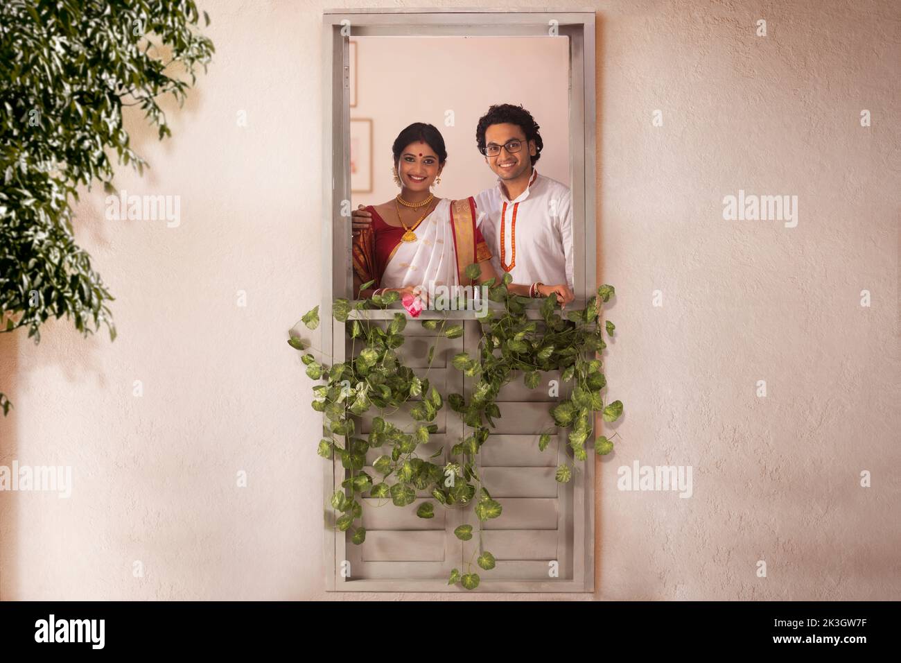 Bengali couple standing by window and looking outside Stock Photo - Alamy