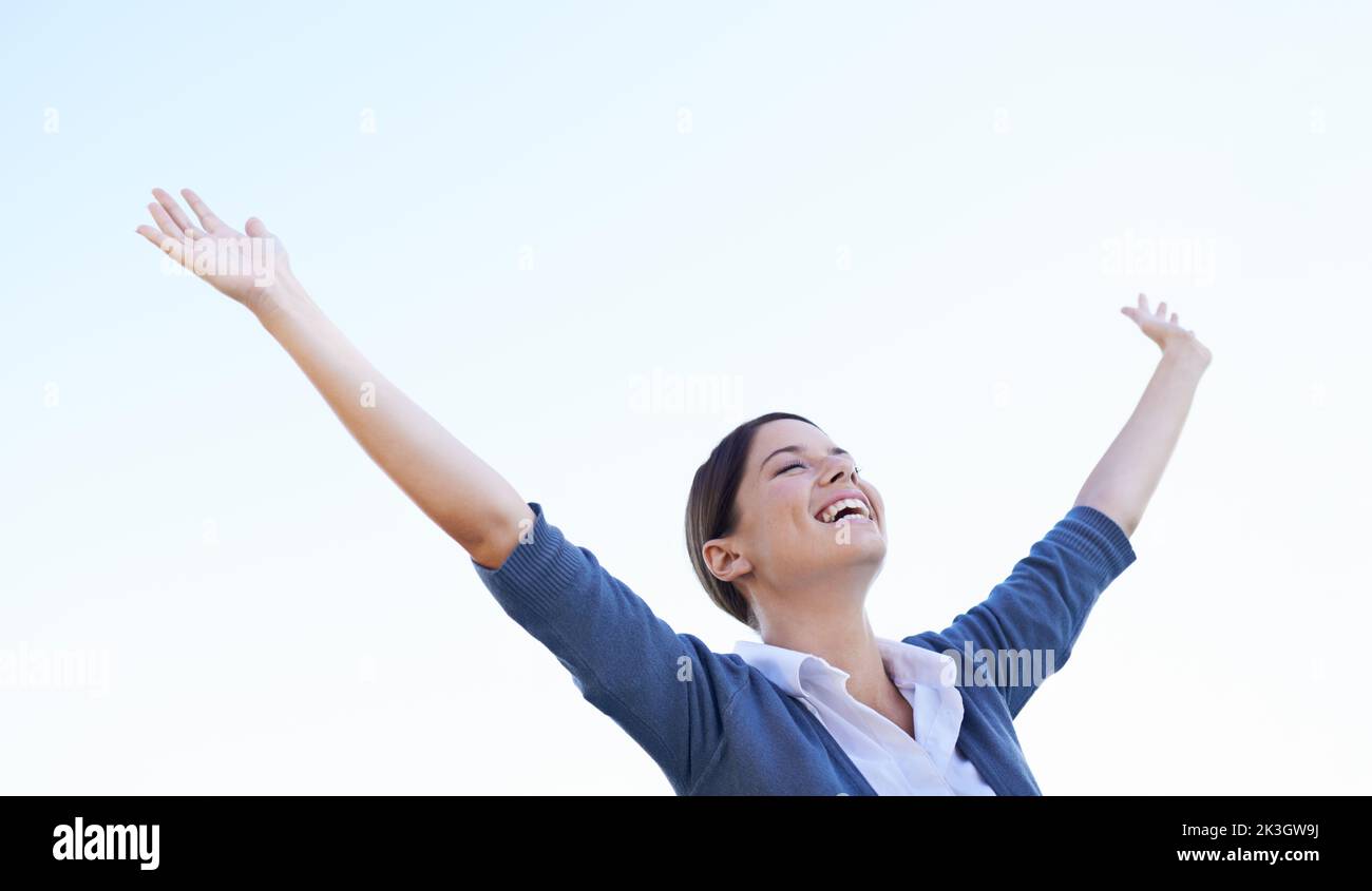 Shes a born winner. An attractive young woman raising her hands in ...