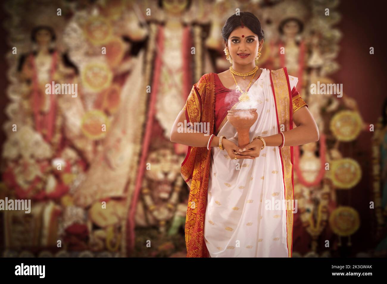 Bengali woman standing with dhunuchi at puja pandal on the occasion of ...