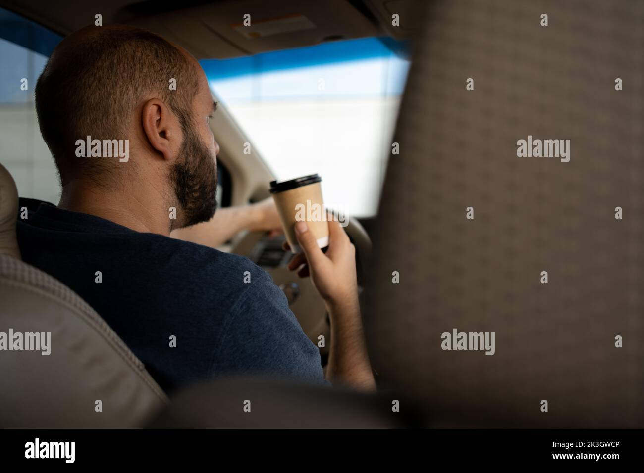 man drinking coffee while driving the car. transportation and vehicle ...