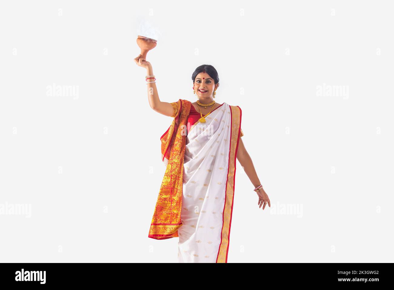 Portrait of Bengali woman performing Dhunuchi dance against white ...