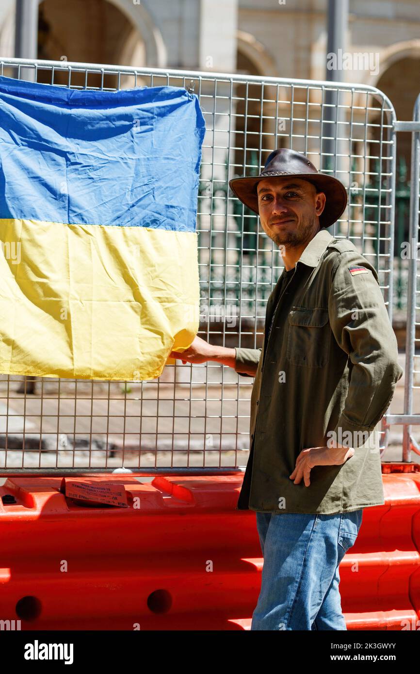 Brisbane, Australia. 24th Sep, 2022. A man hangs a Ukrainian flag ...