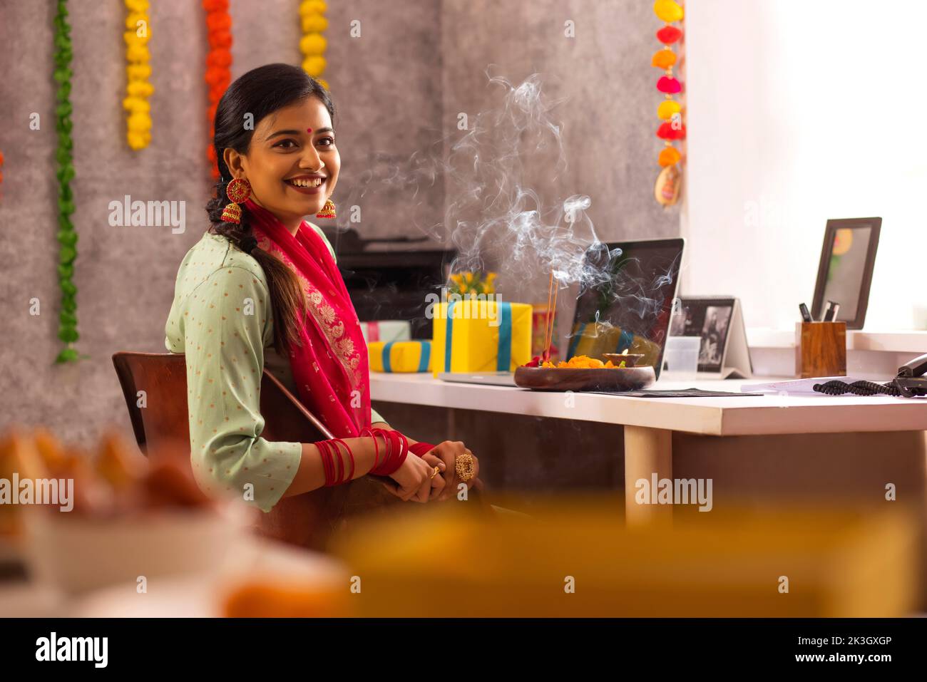 Female employees looking away while sitting in office during Diwali ...
