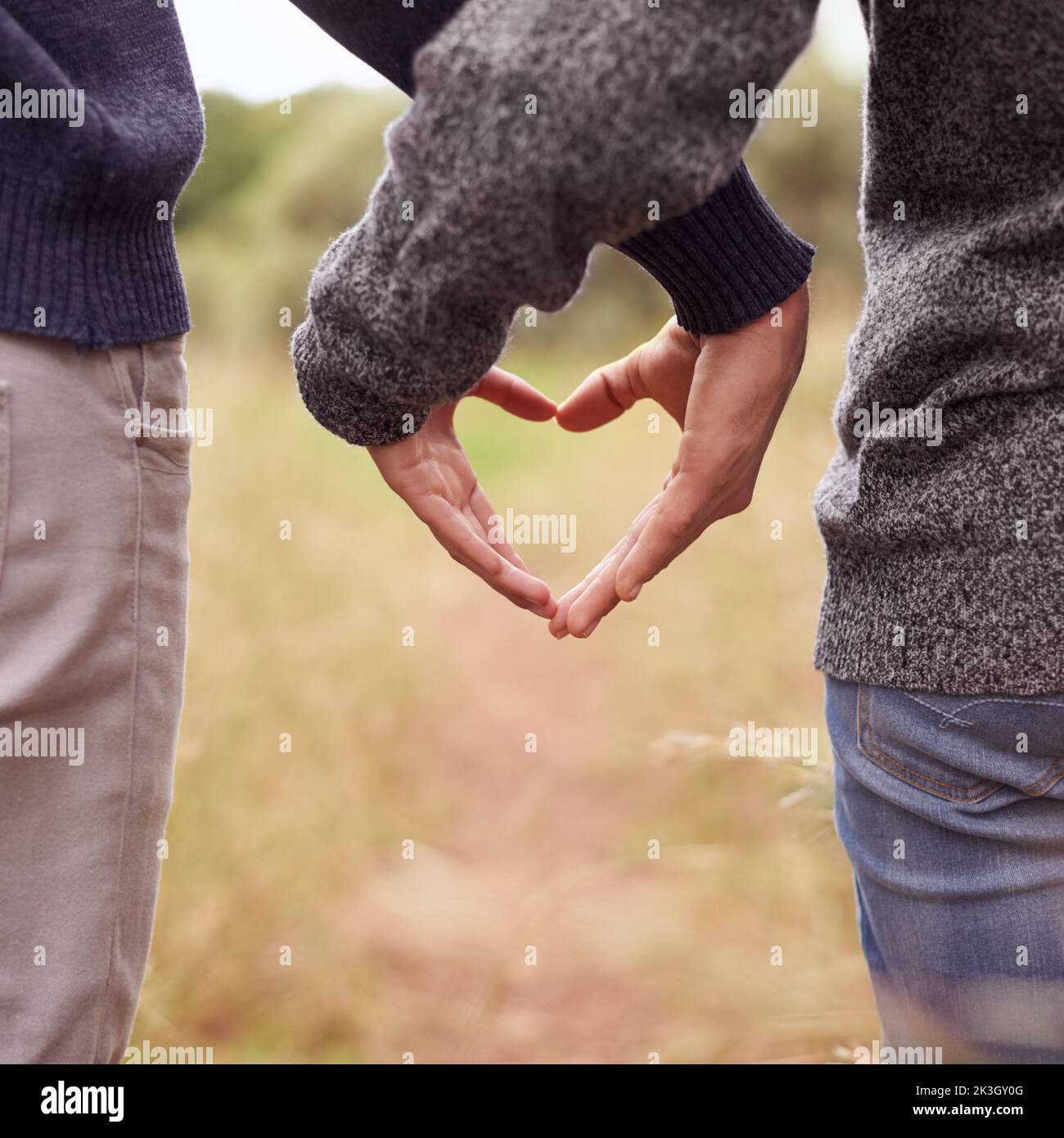 Heart-shaped love. two young people outside making a heart shape with ...