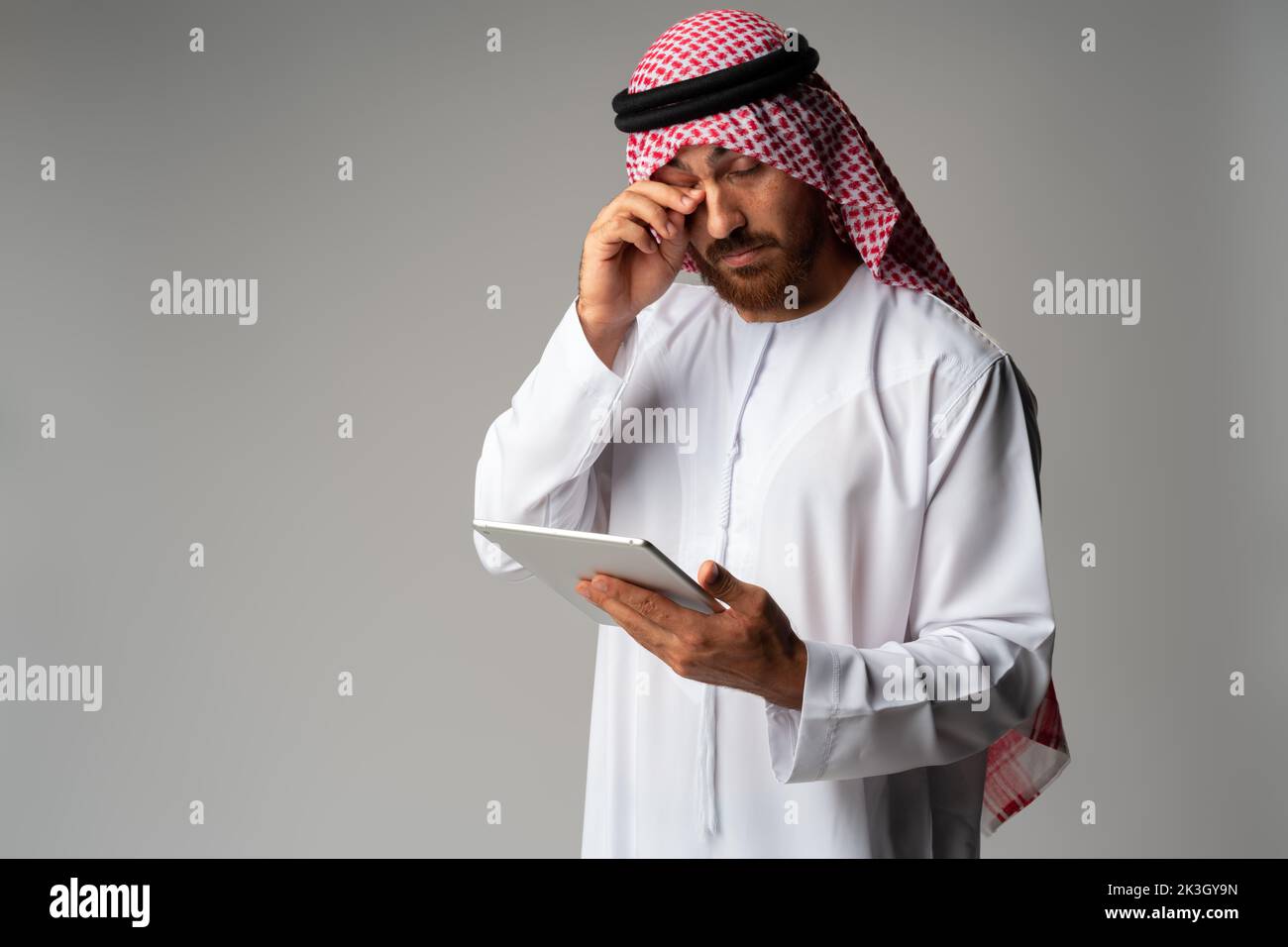 Arab businessman using digital tablet on gray background Stock Photo ...