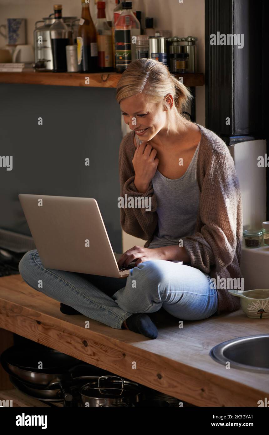 Video chatting from anywhere at home. a young woman sitting cross ...