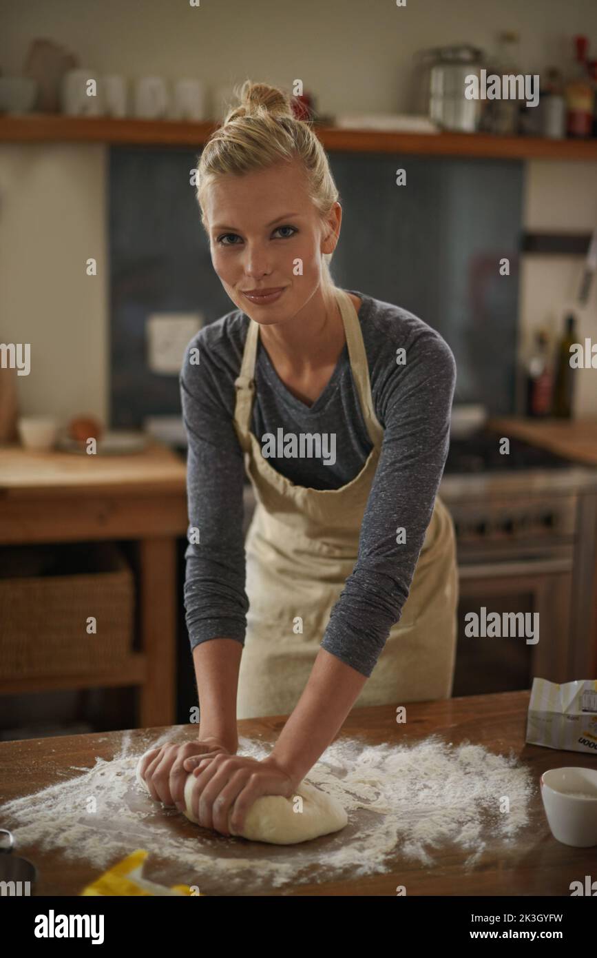 Making her own bread. a female baker kneading dough for homemade bread ...