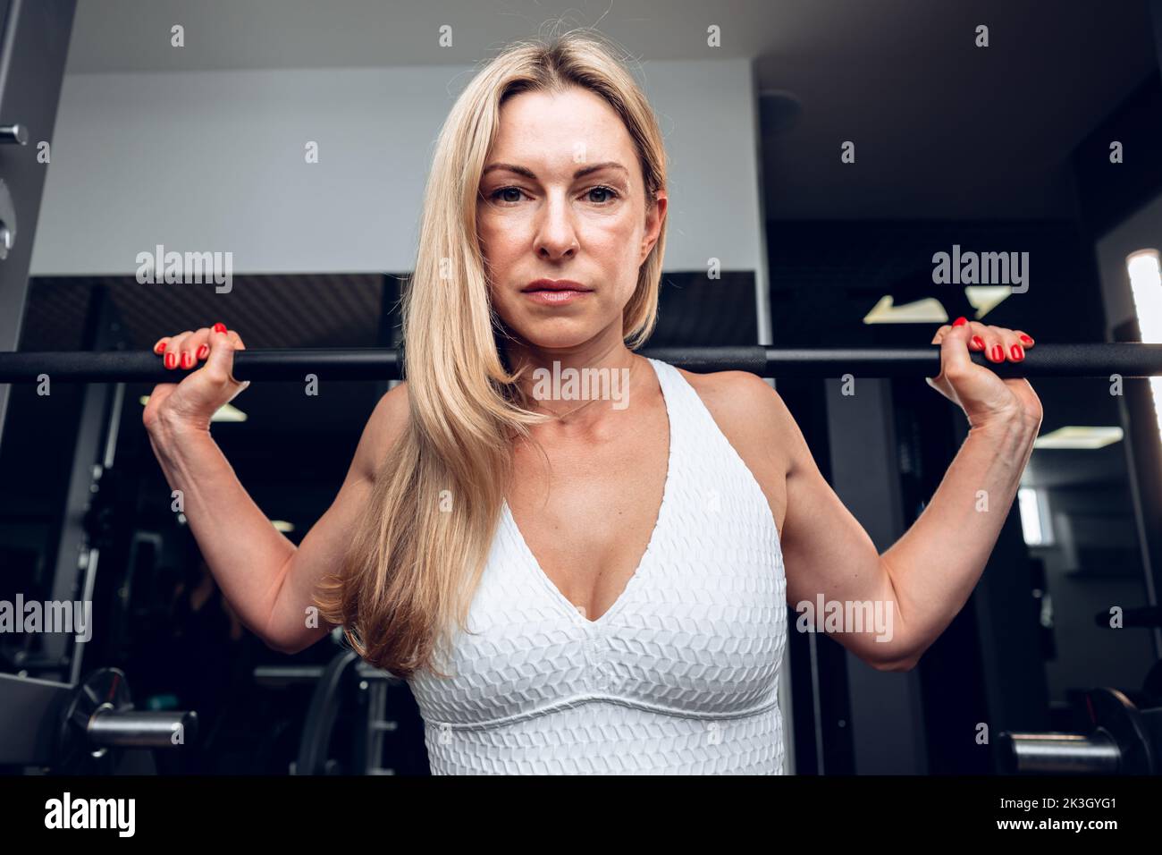 Middle-aged fitness woman doing squat exercise in a gym Stock Photo - Alamy