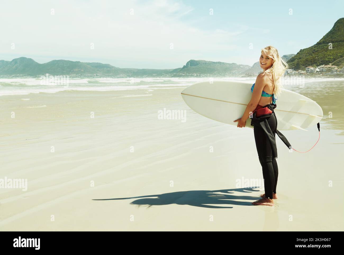 On her way into the ocean. A young female surfer holding her surfboard ...