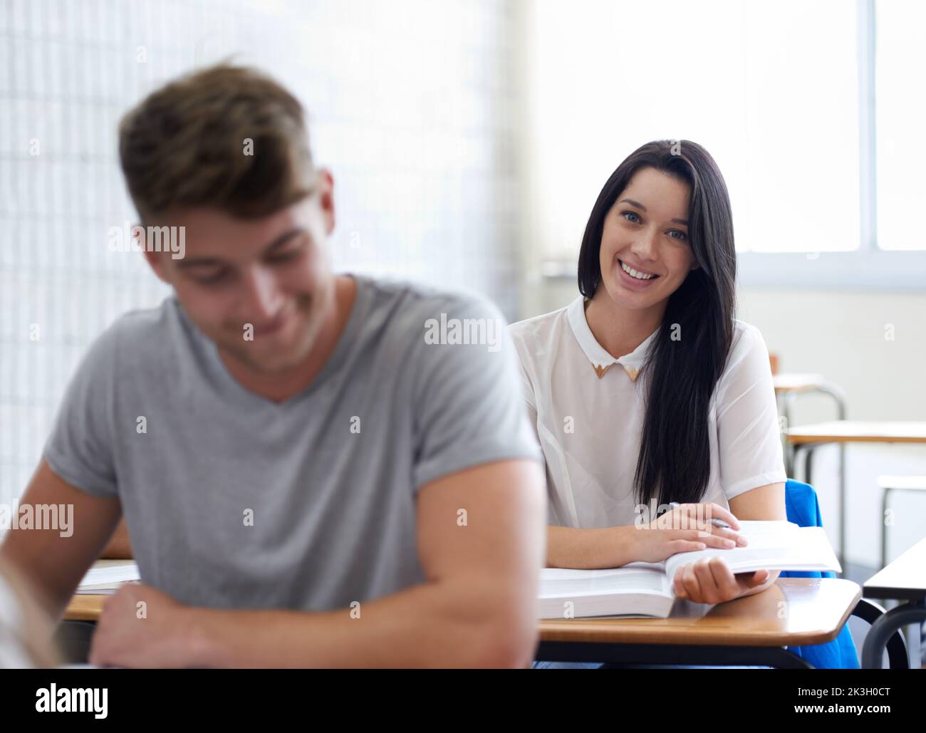 Aiming for an A. Portrait of a young college student studying in class ...