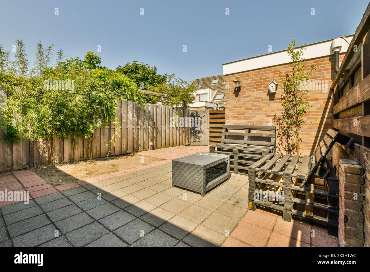 Neat powerful patio with sitting area and small garden near wooden ...