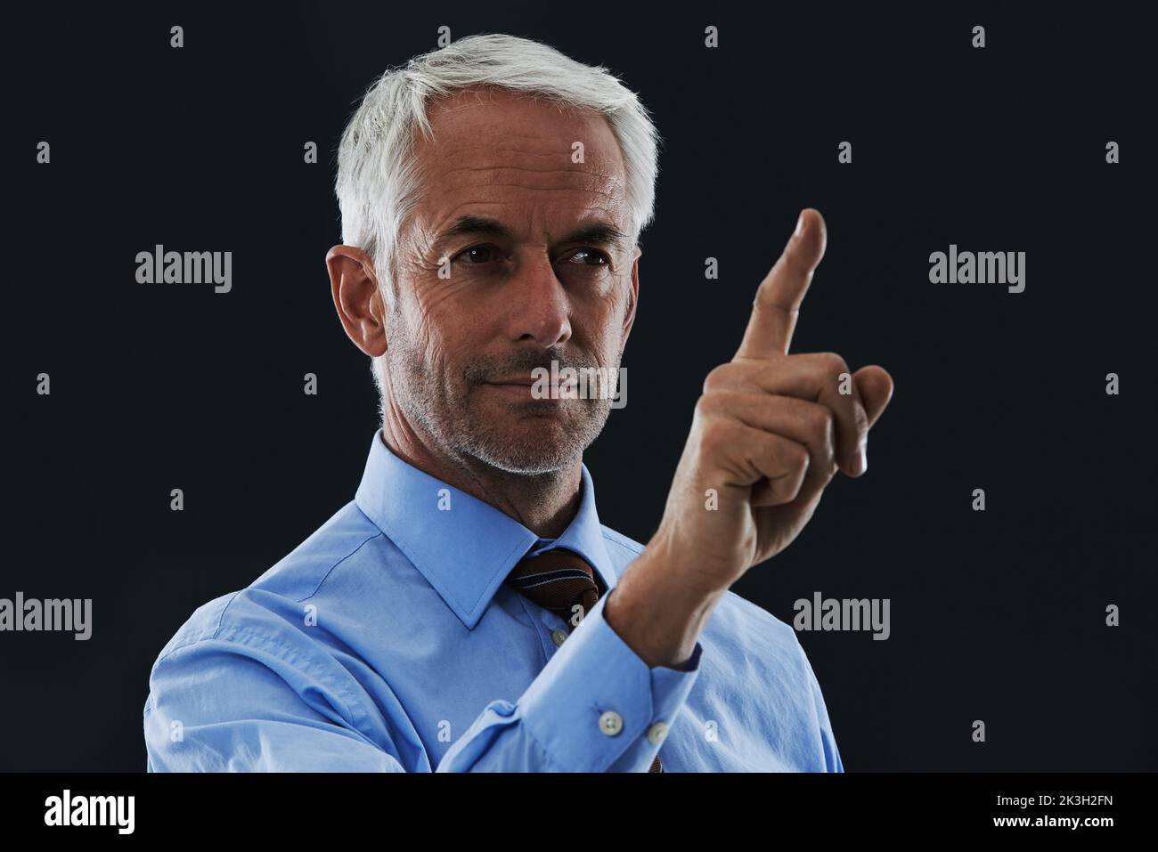 Using a digital interface. A handsome businessman using a digital ...