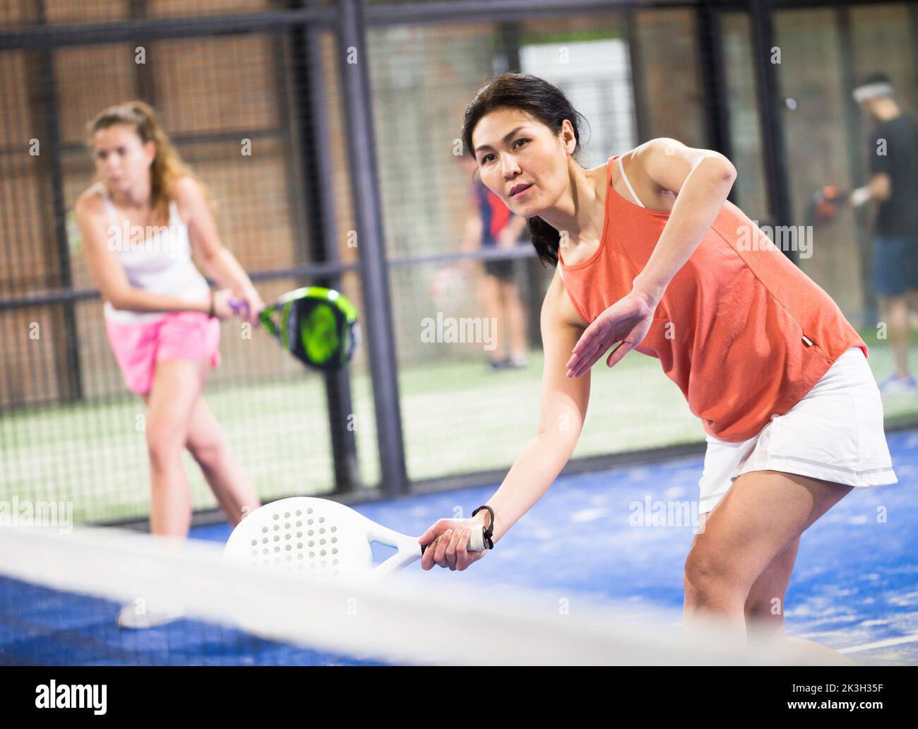Sporty asian woman playing padel on indoor court Stock Photo - Alamy