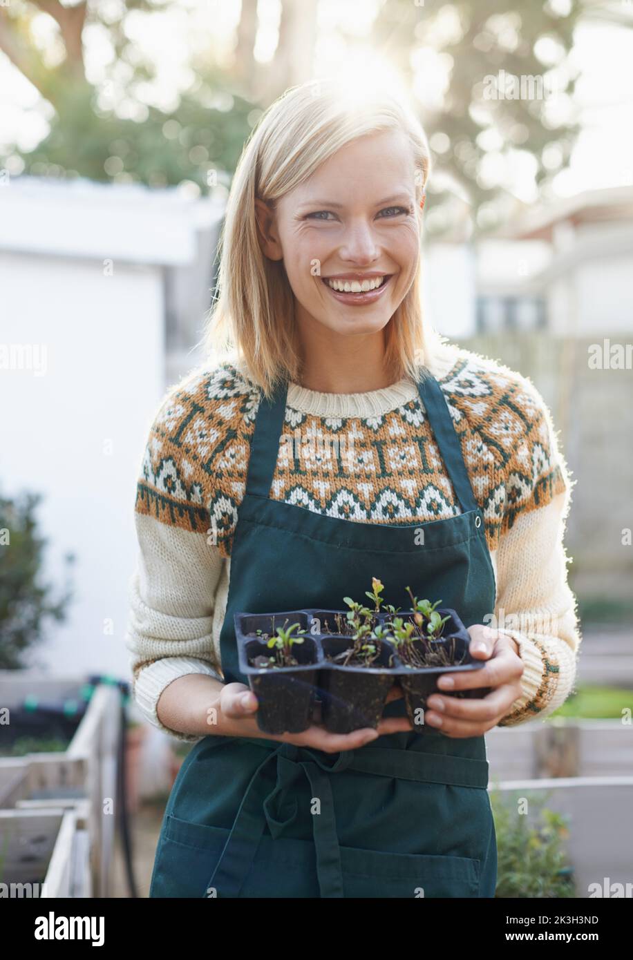 Giving back to the earth. A young gardener outside in a nursery Stock ...