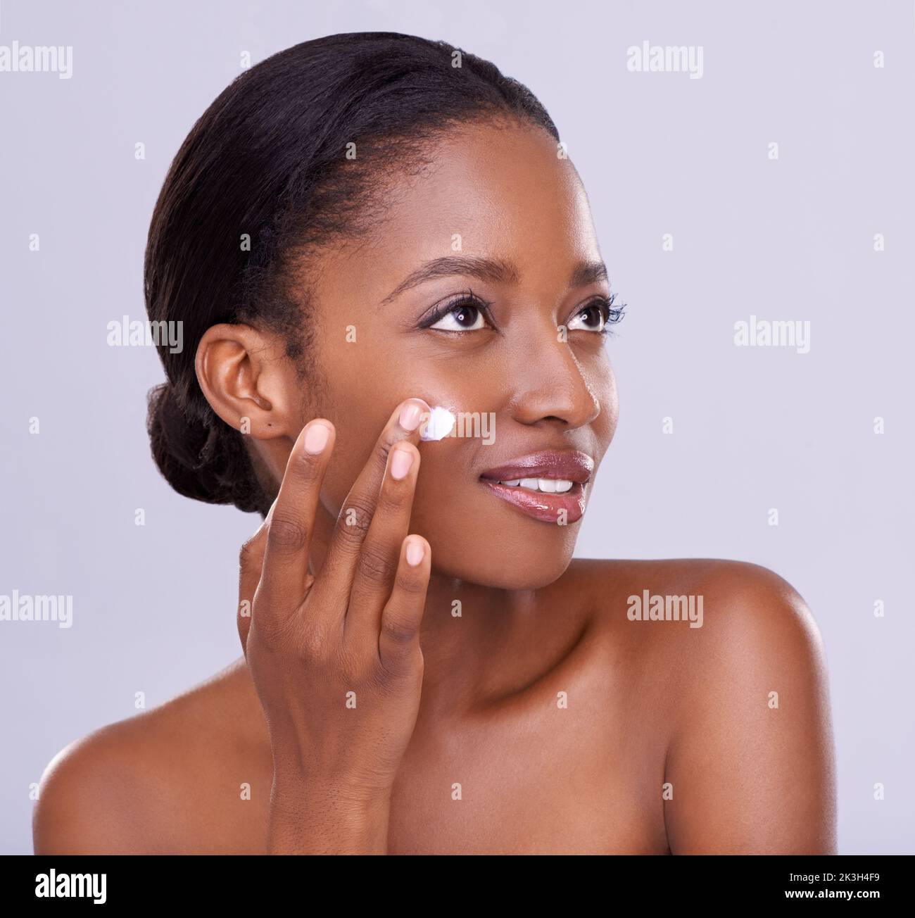 Taking care of her skin. an attractive young woman touching her skin ...