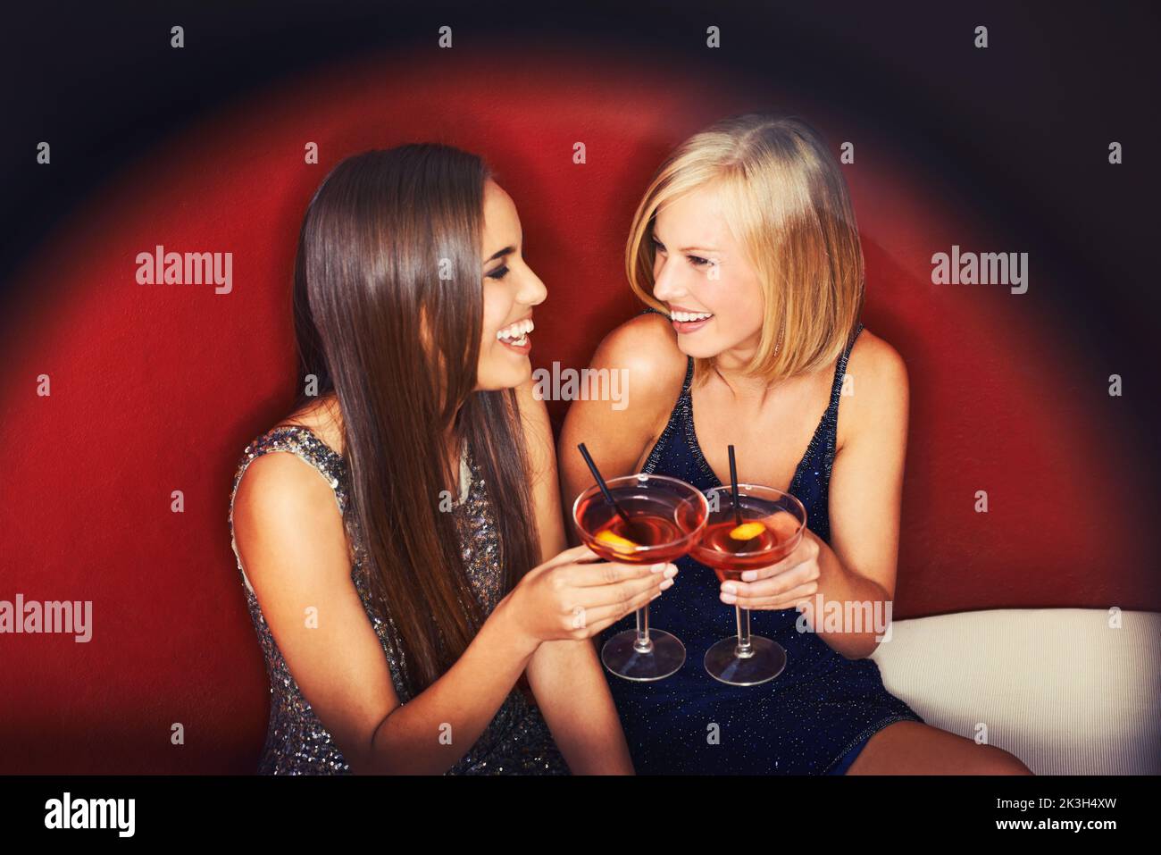 Catching up over a cocktail. Two young women enjoying cocktails in a nightclub Stock Photo - Alamy