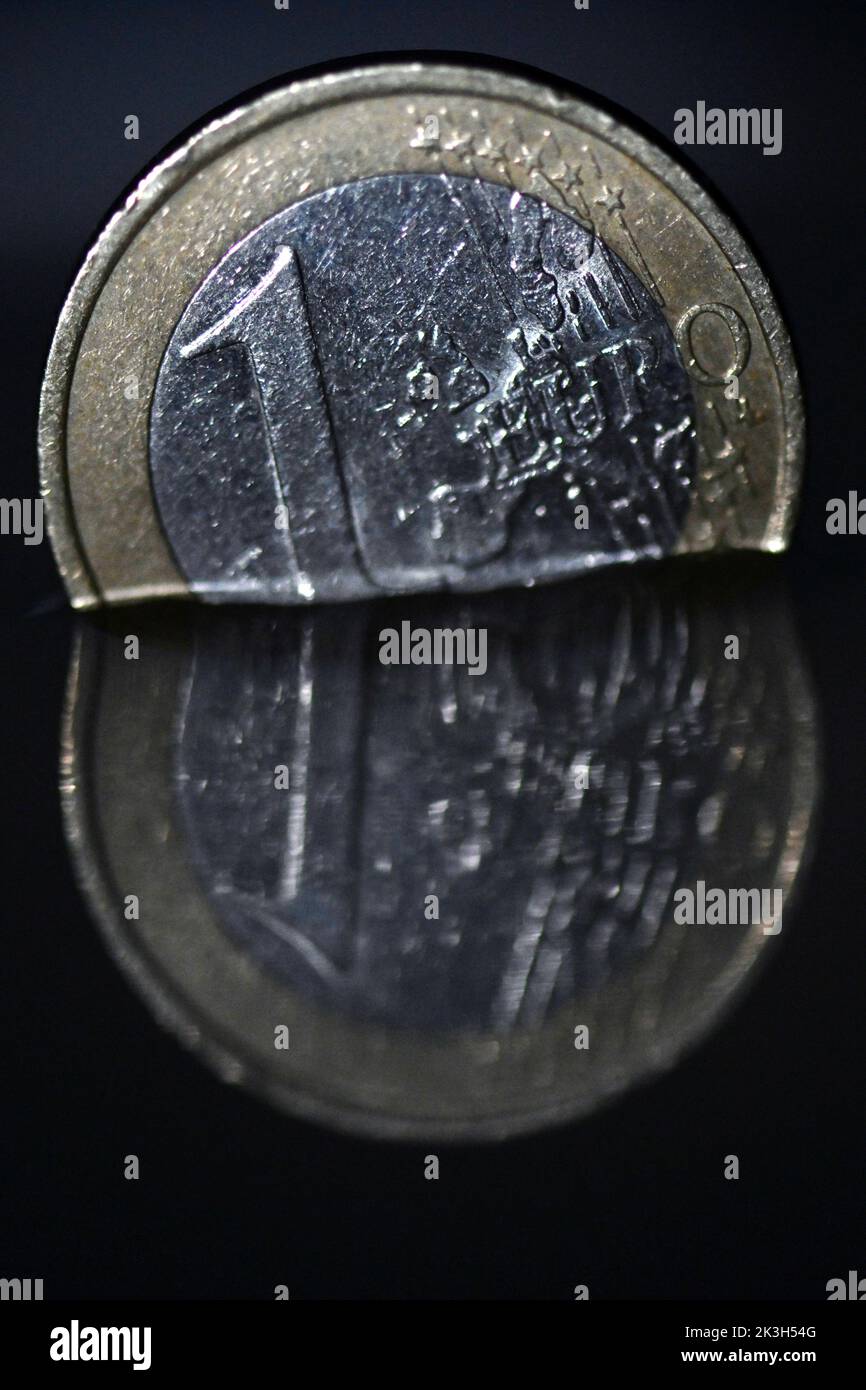 Cologne, Germany. 26th Sep, 2022. A euro is reflected on a surface of ...