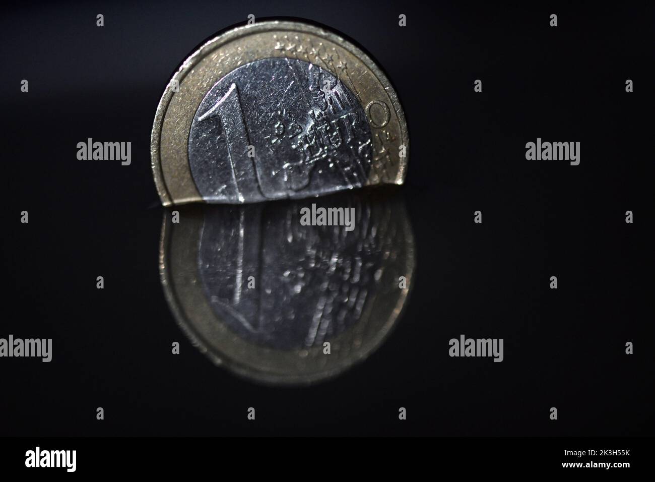 Cologne, Germany. 26th Sep, 2022. A euro is reflected on a surface of ...