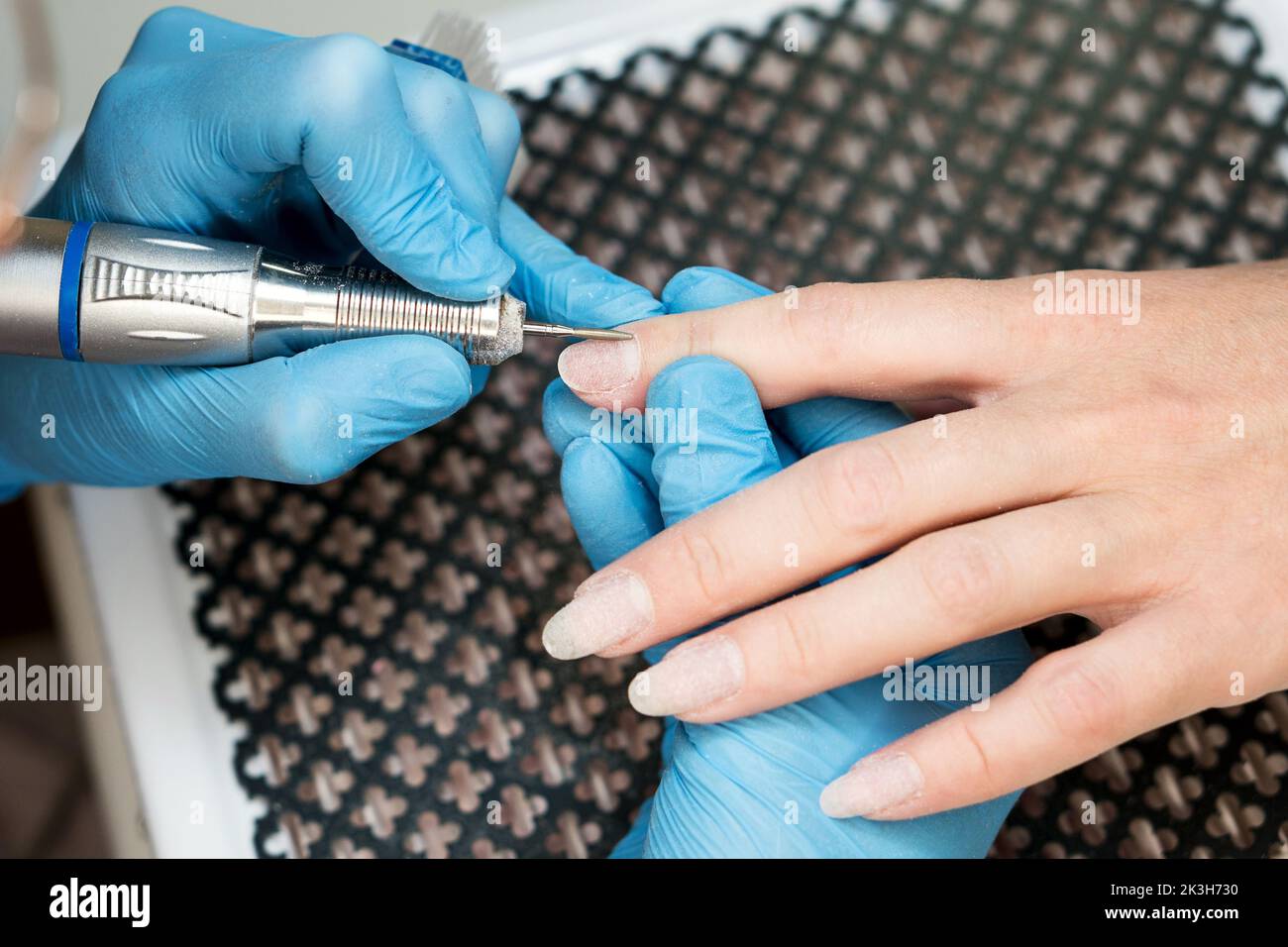 Process professional hardware manicure. Master manicurist in blue ...