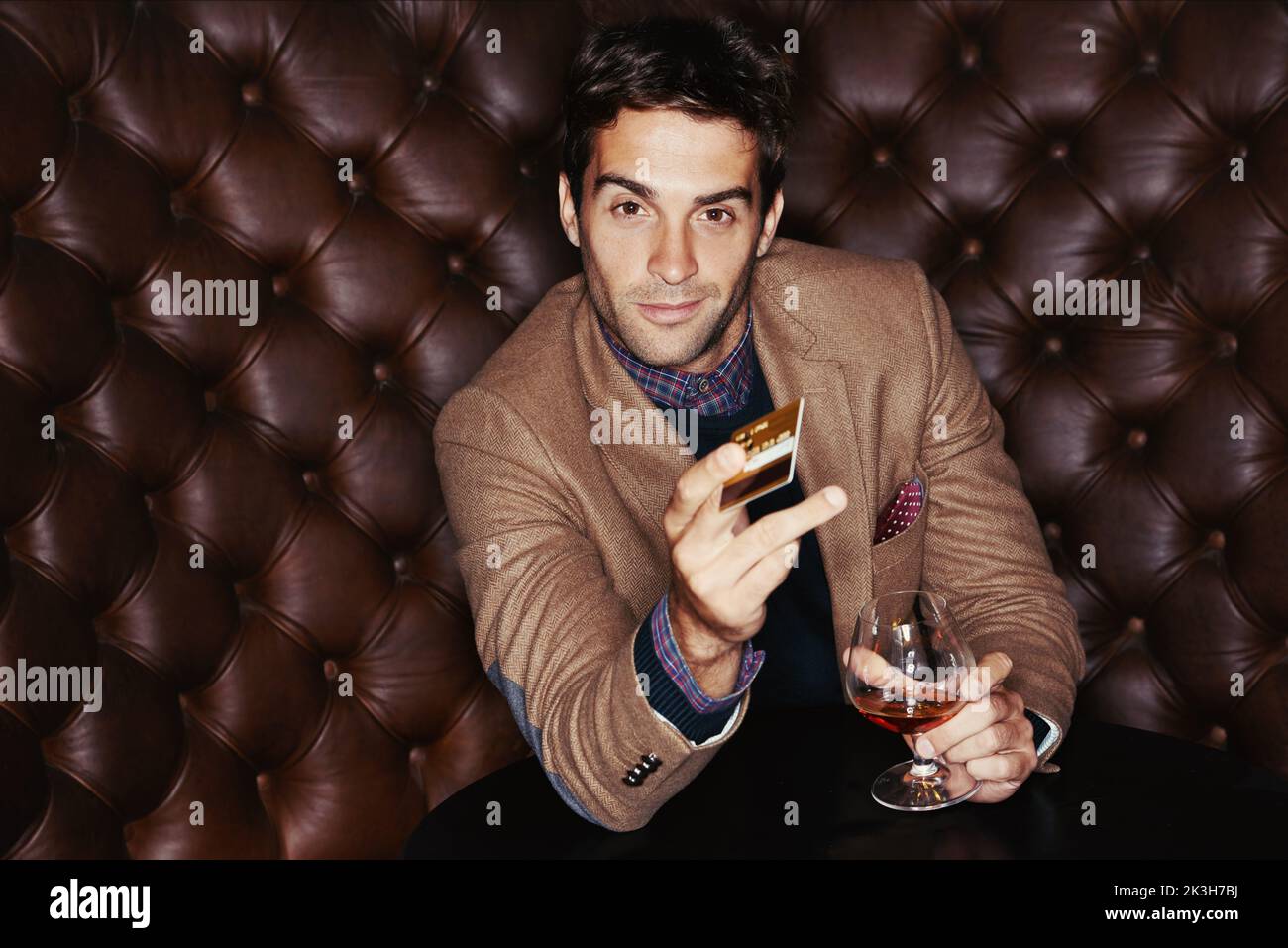 I enjoy the finer things. Portrait of a handsome young man drinking and ...