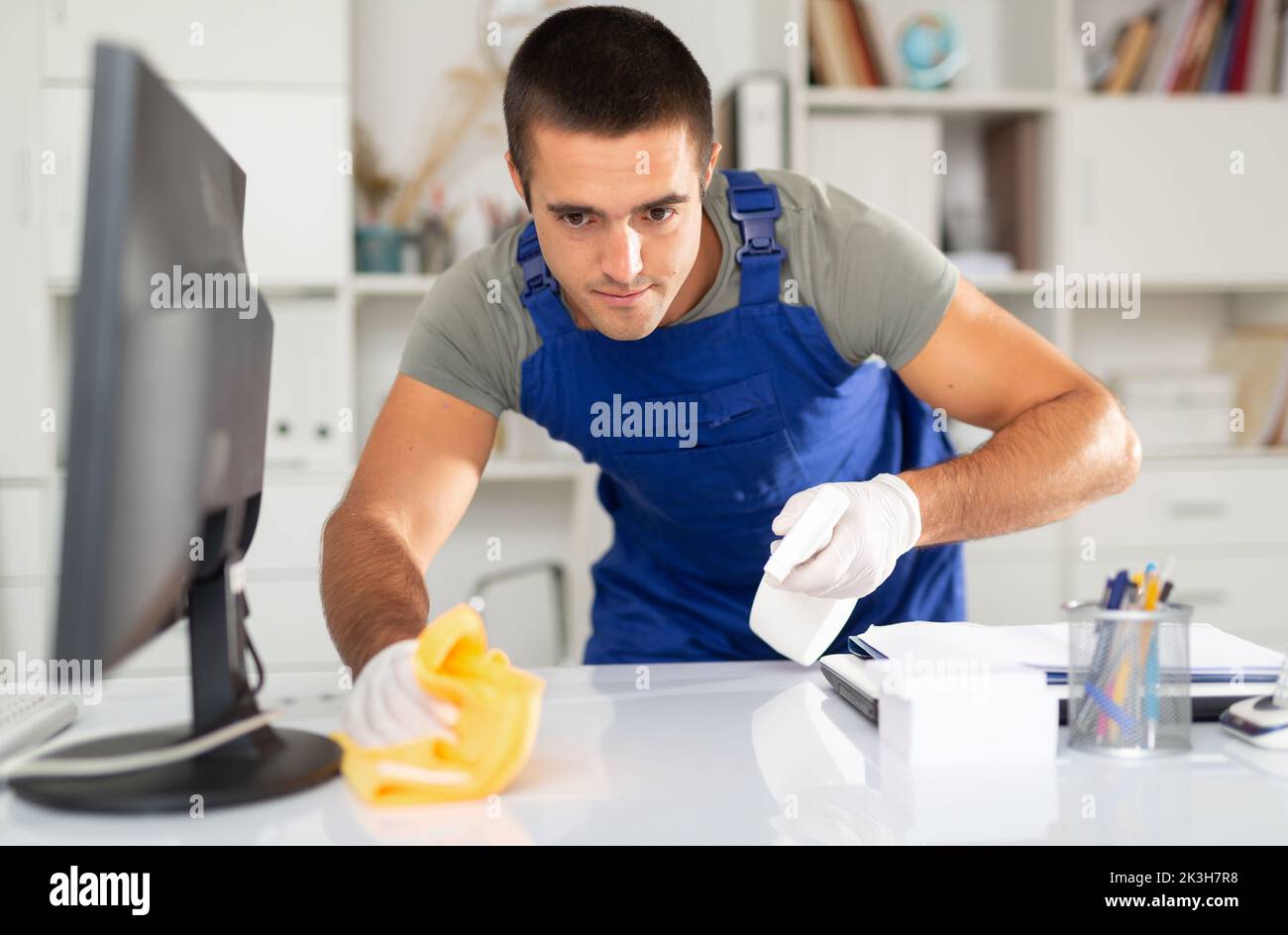 Cleaning worker wiping office desk with detergent Stock Photo - Alamy