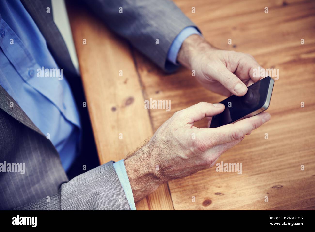 Wireless at work. a businessman sitting at a desk and using a mobile ...
