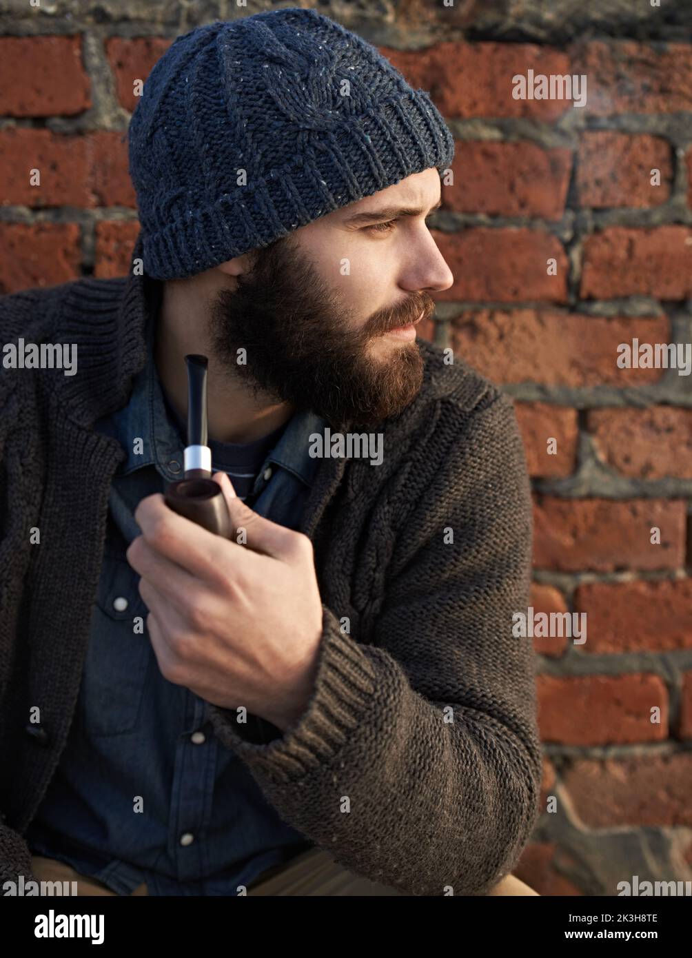 Smoking a pipe. a bearded man smoking a pipe outside Stock Photo - Alamy