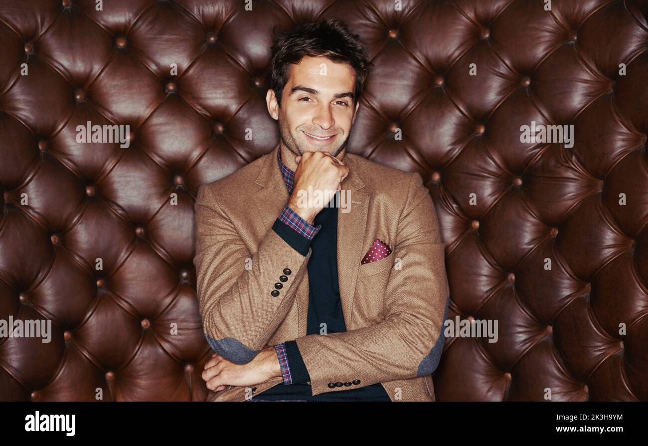 Looking good and he knows it. Portrait of a stylish young man sitting ...