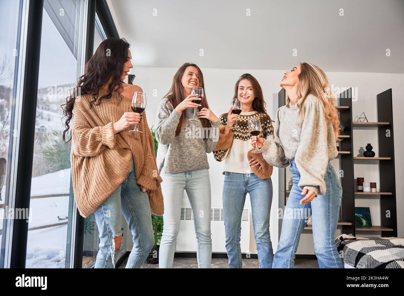 Young women enjoying winter weekends inside contemporary barn house ...