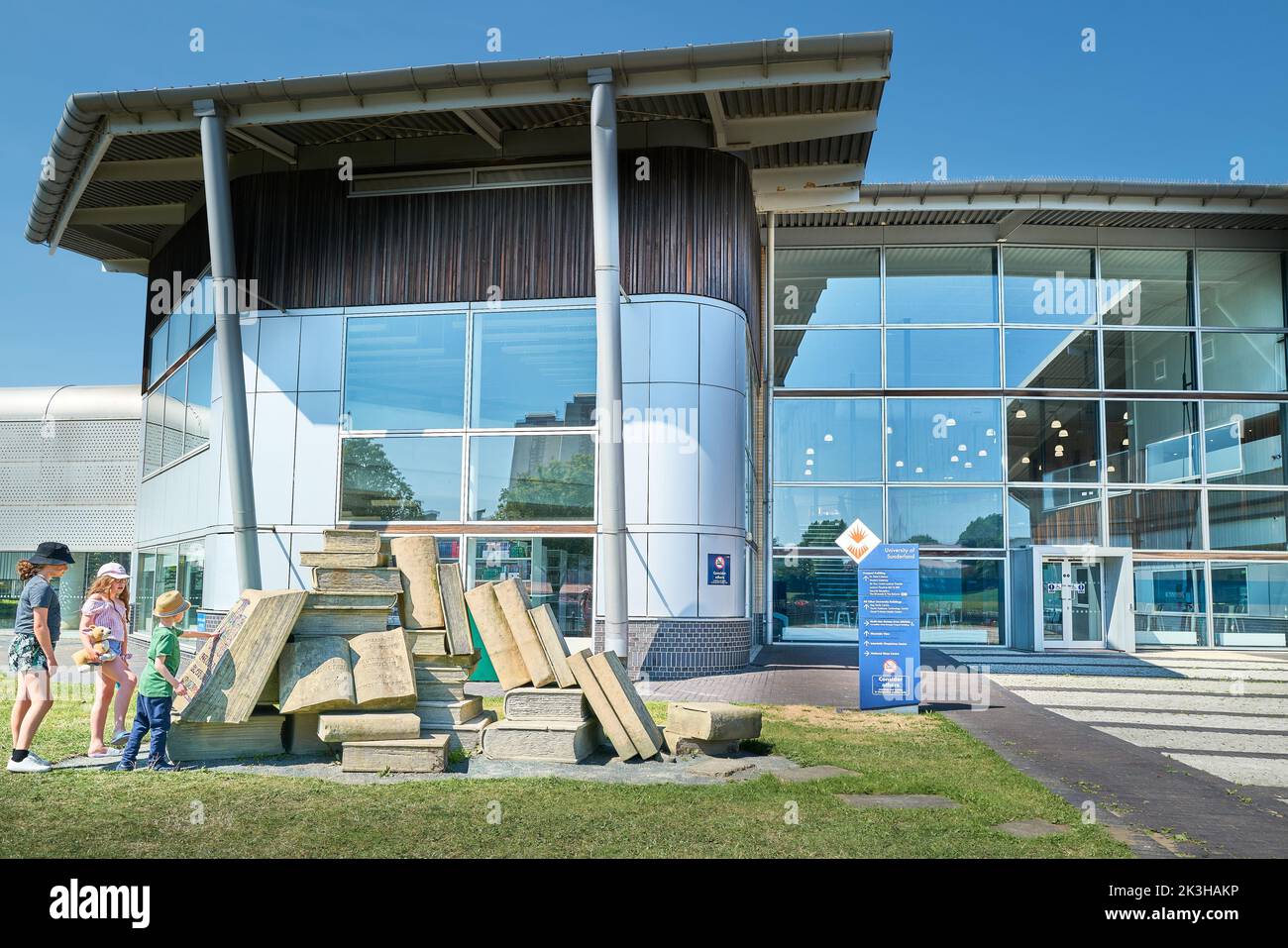 Three children play on the sculpture of books at the entrance to the ...