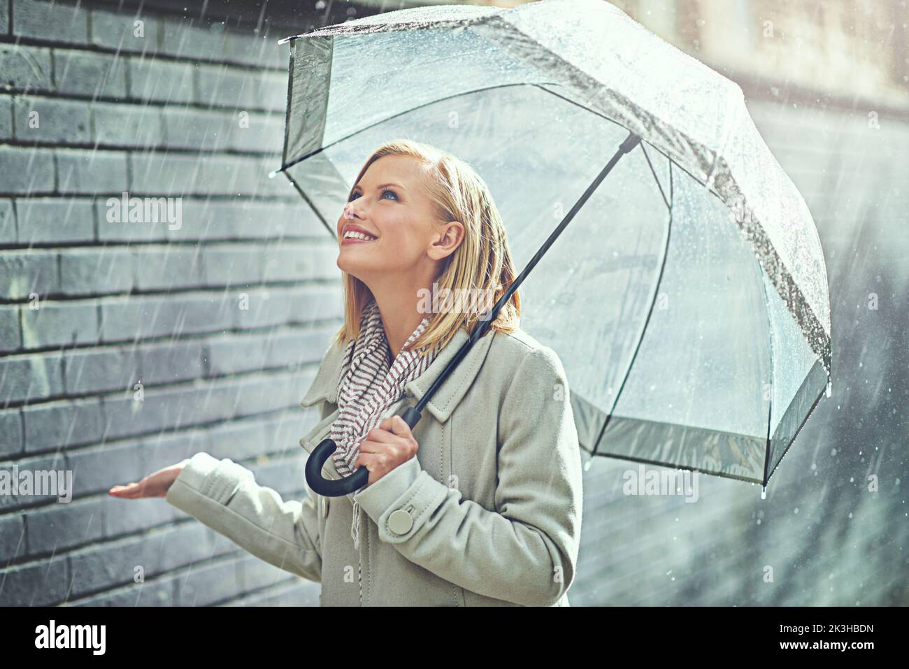 Its raining happiness. an attractive young woman walking in the rain ...