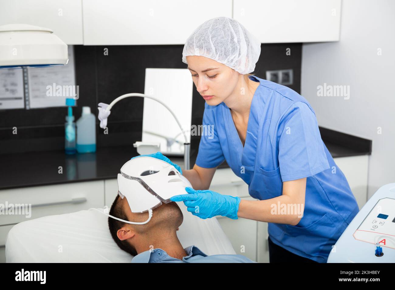 Beautician preparing male client for procedure of phototherapy Stock ...