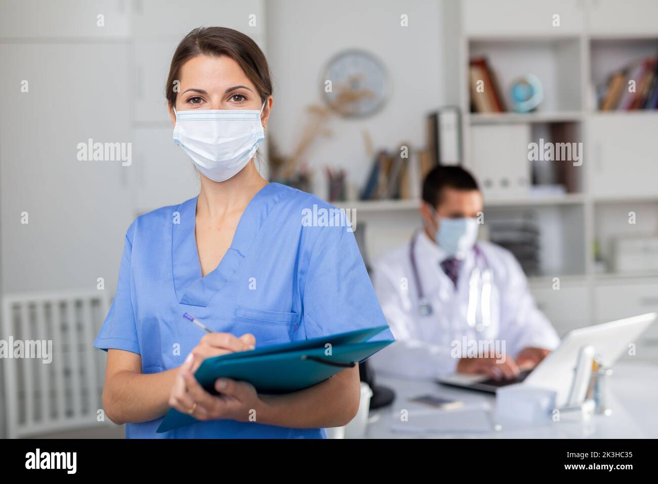 Female doctor filling out medical form on clipboard Stock Photo - Alamy