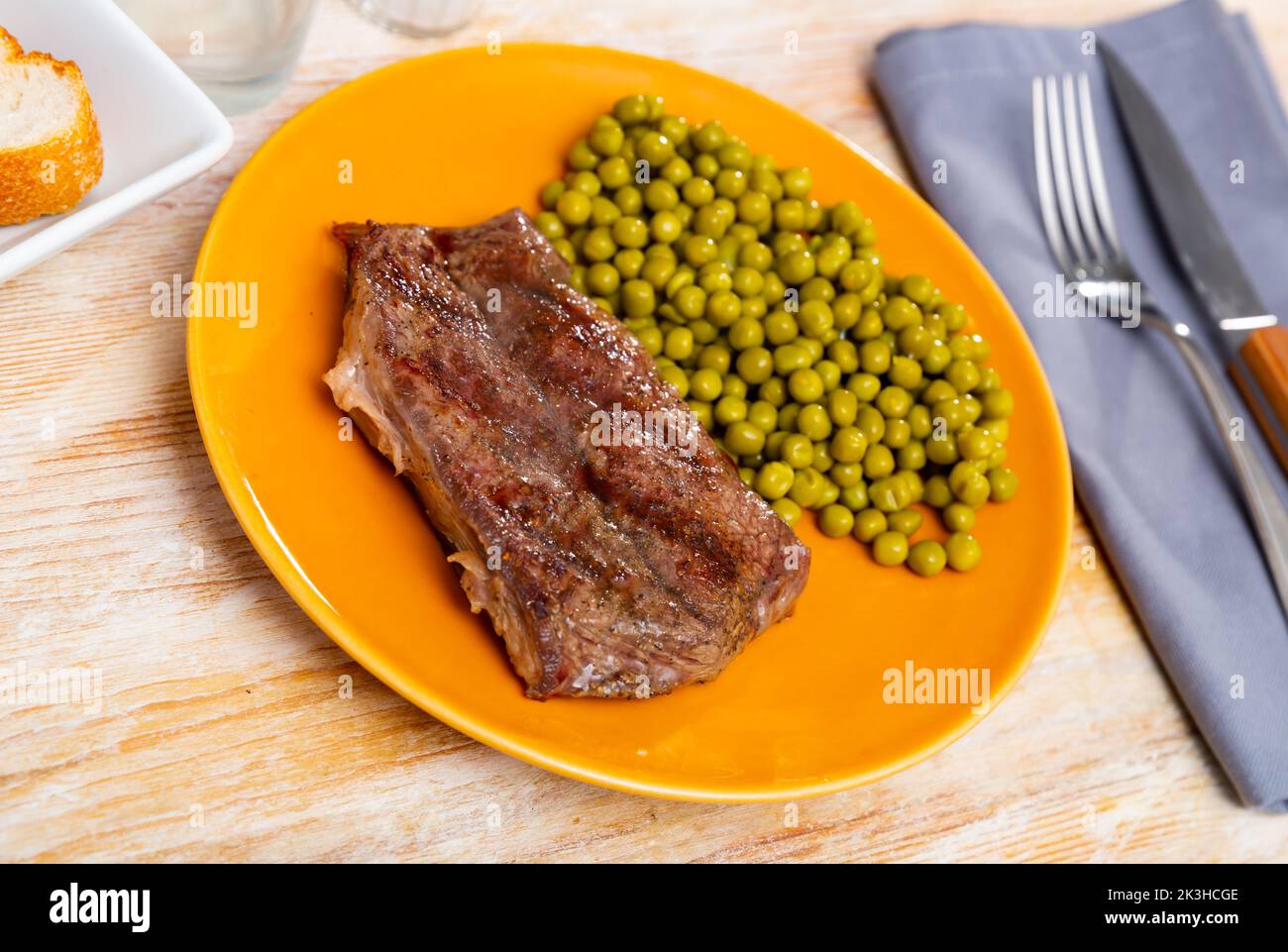 Fried beef cutlet with green peas on plate Stock Photo - Alamy