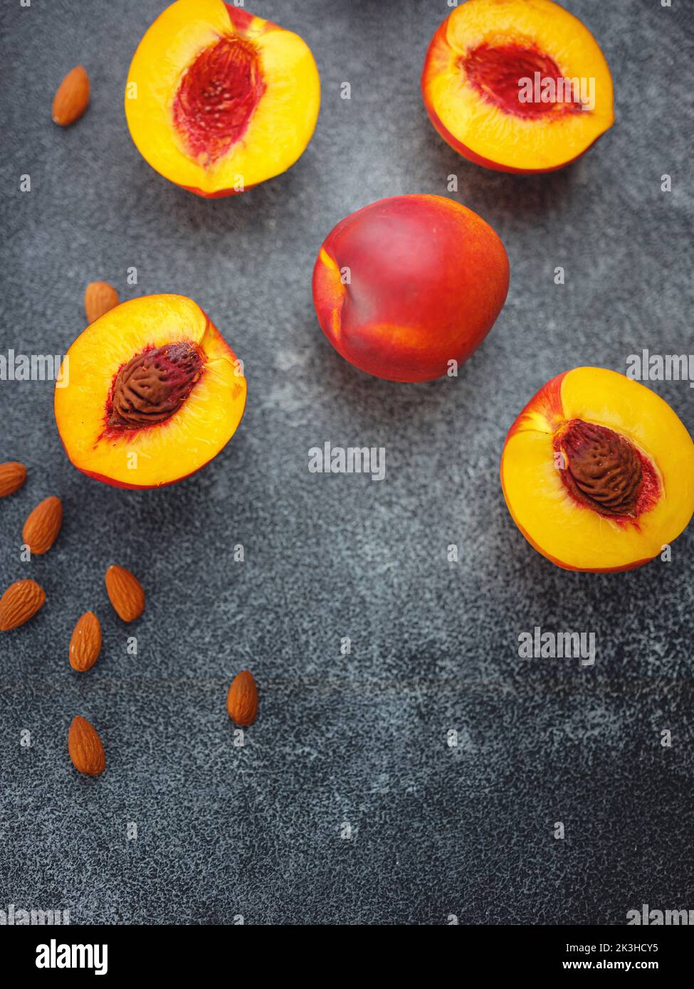 fresh sweet peaches and almond nuts on dark table. Fresh organic fruit ...