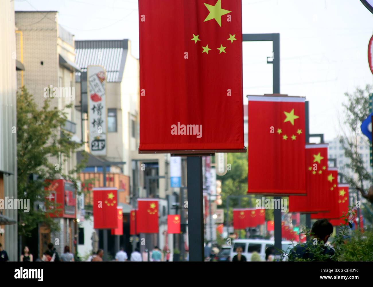 SUZHOU, CHINA - SEPTEMBER 26, 2022 - People pass under national flags ...
