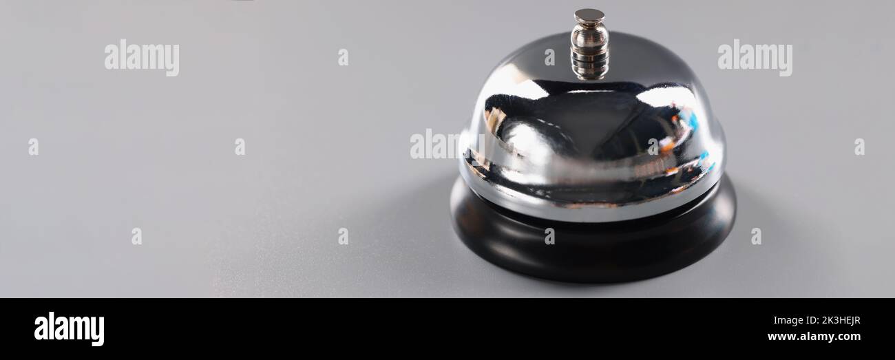 Silver bell stands on grey surface to attract attention, press bell to ...