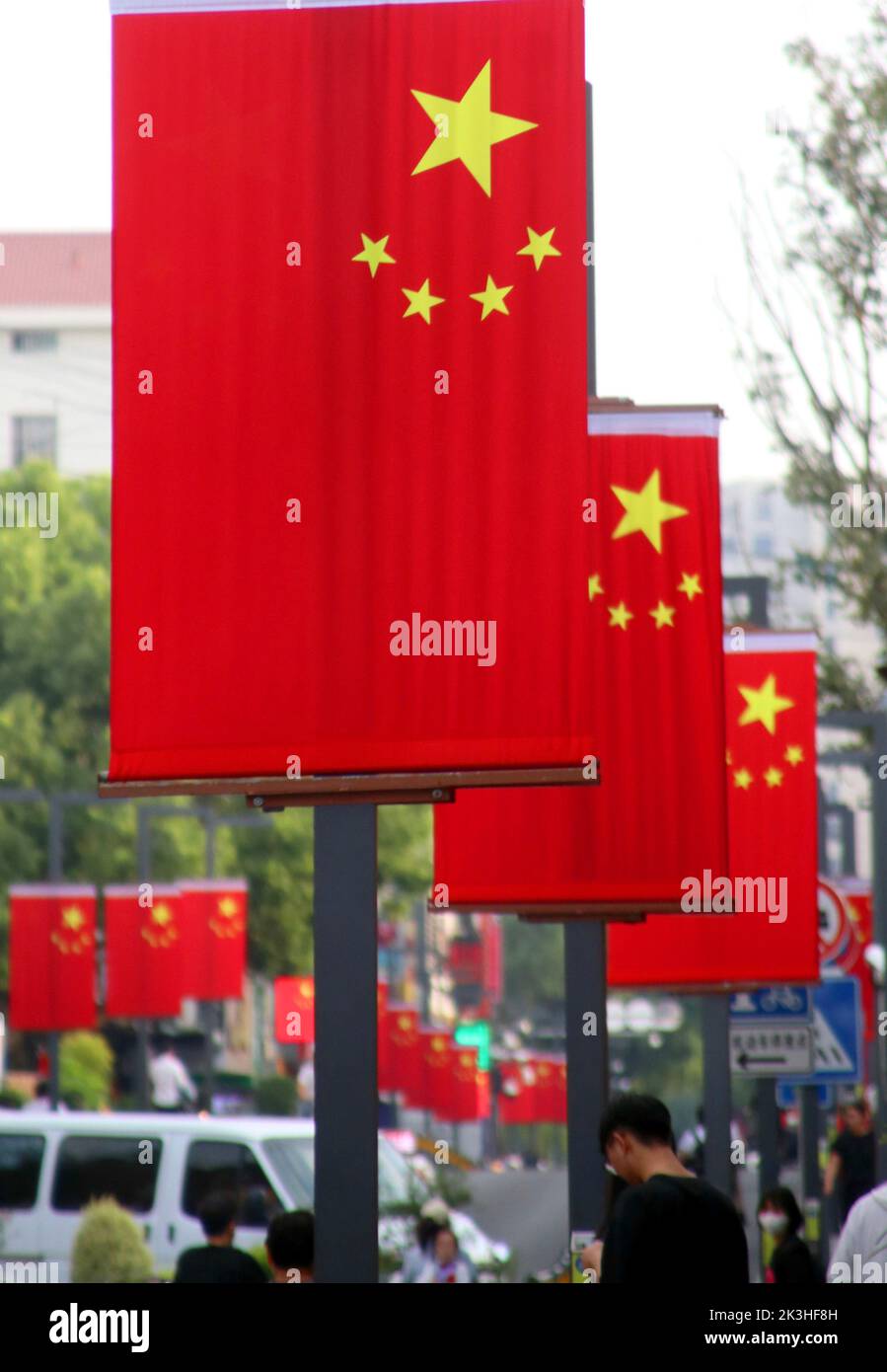 SUZHOU, CHINA - SEPTEMBER 26, 2022 - People pass under national flags ...
