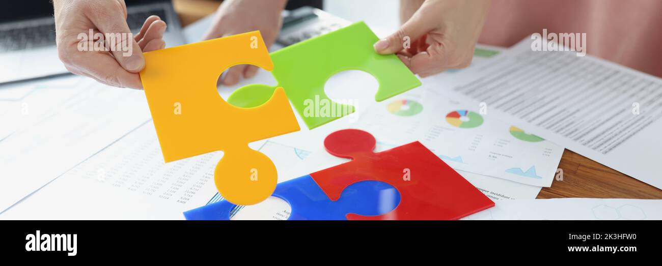 Coworkers solving jigsaw puzzle on workplace, colourful parts Stock ...