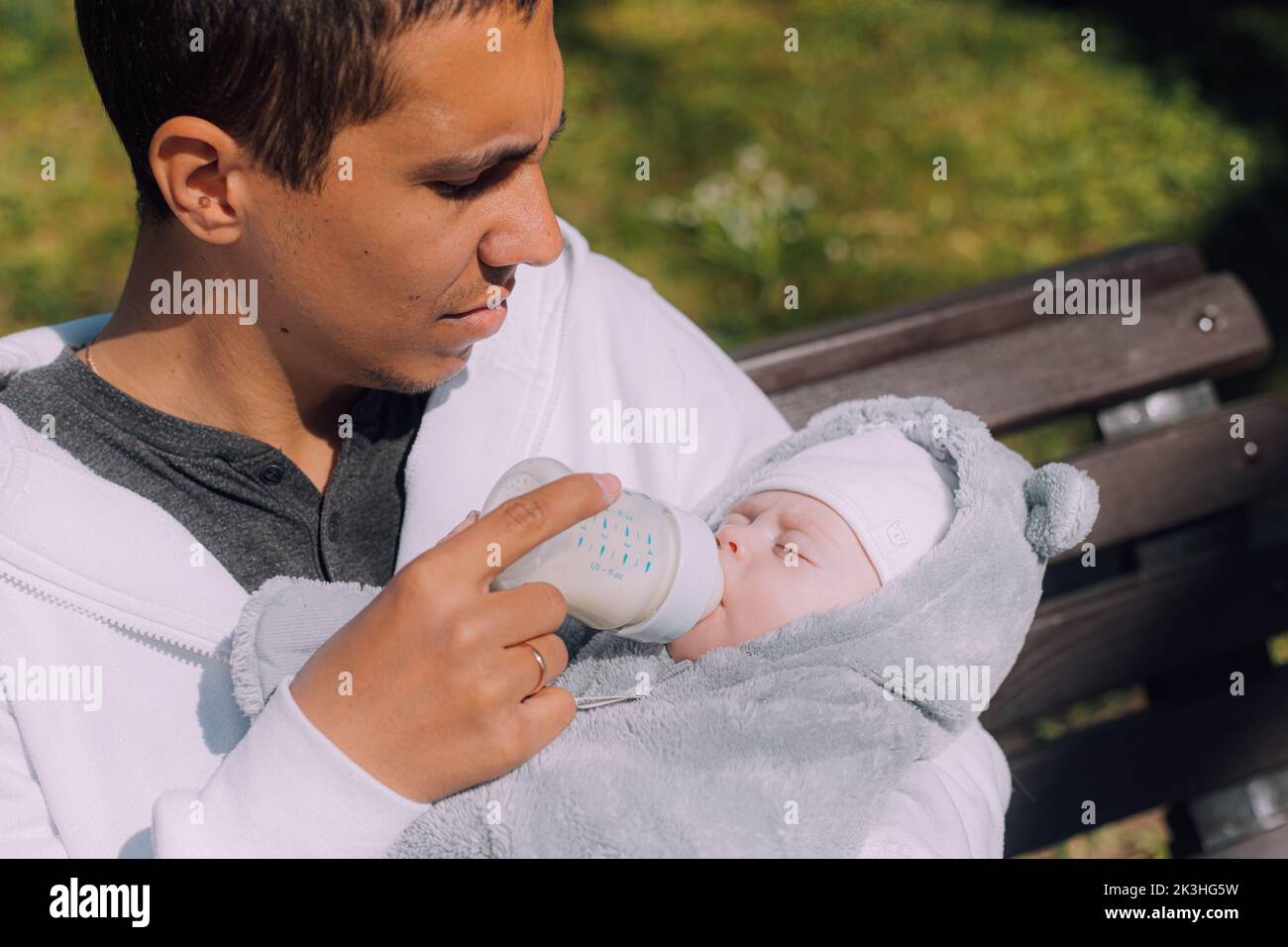 dad feeds the baby from a bottle . baby food. father-son relationship ...