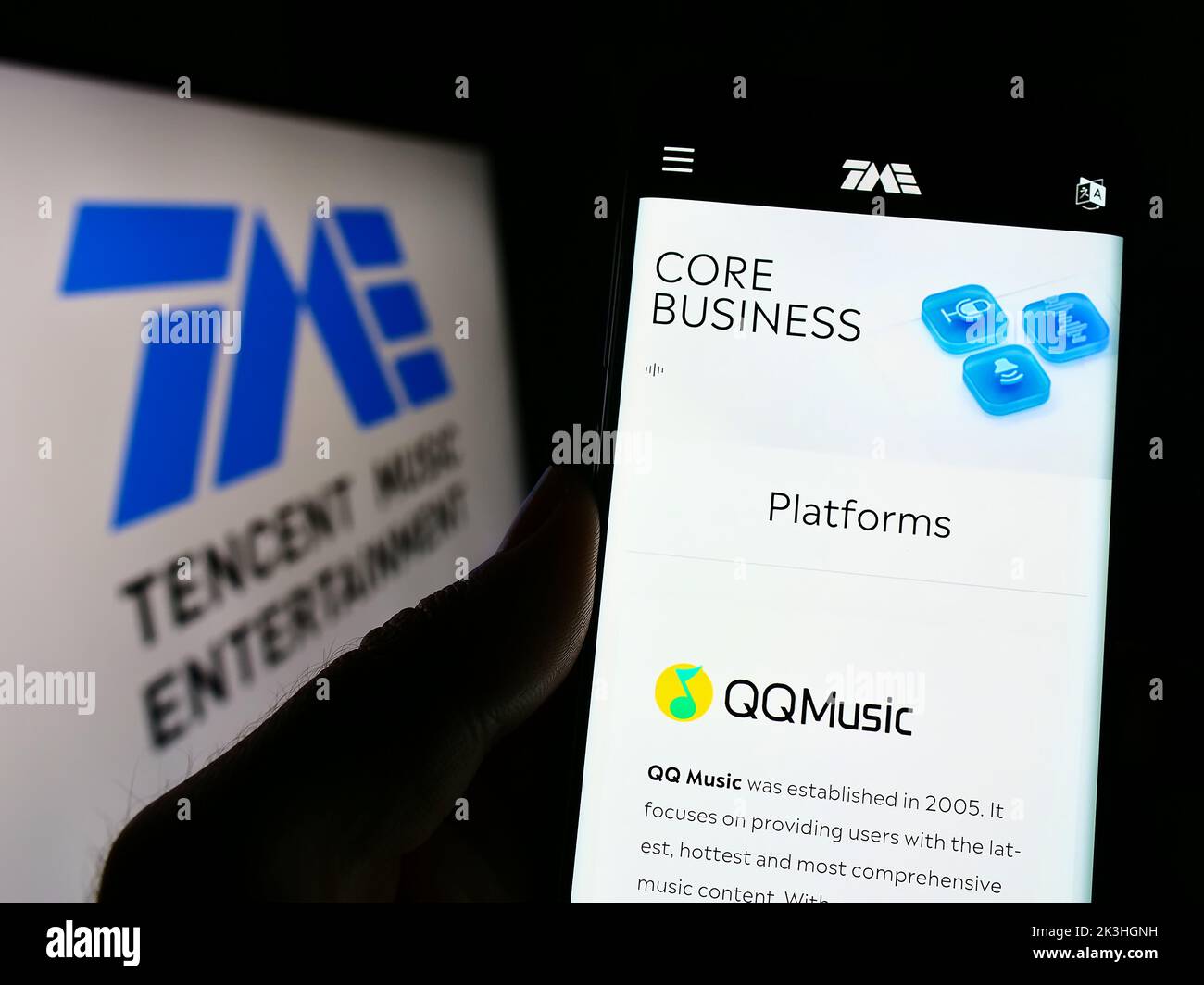 Person holding cellphone with webpage of company Tencent Music ...