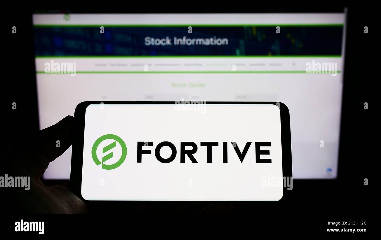 Person holding cellphoe with logo of US technology company Fortive ...